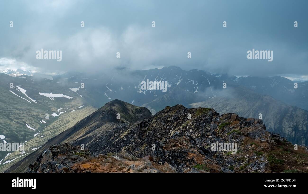 Clouds skim across the peaks on a gloomy day in the mountains Stock ...