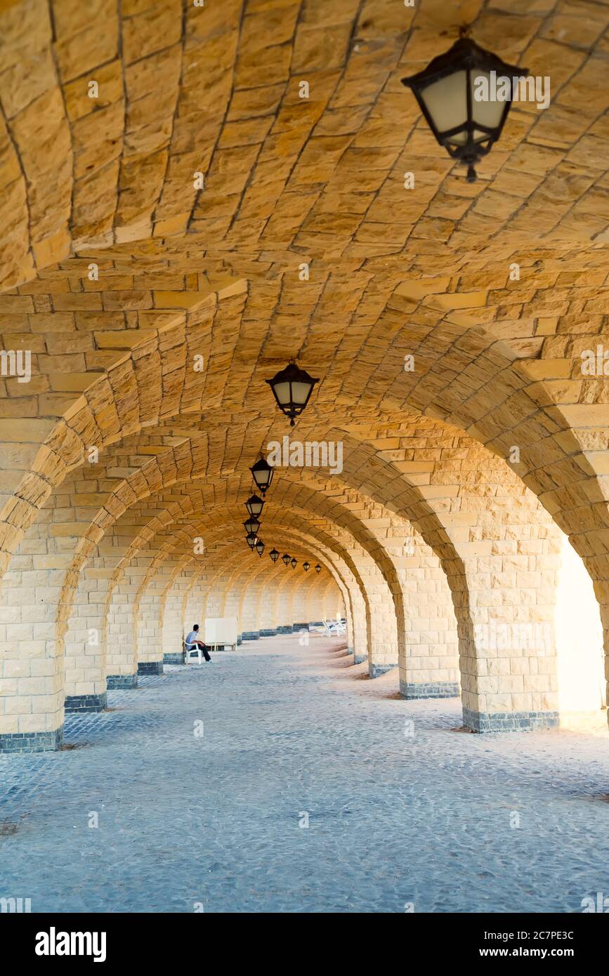 Old architectural perspective from arched brick corridor with arches ...