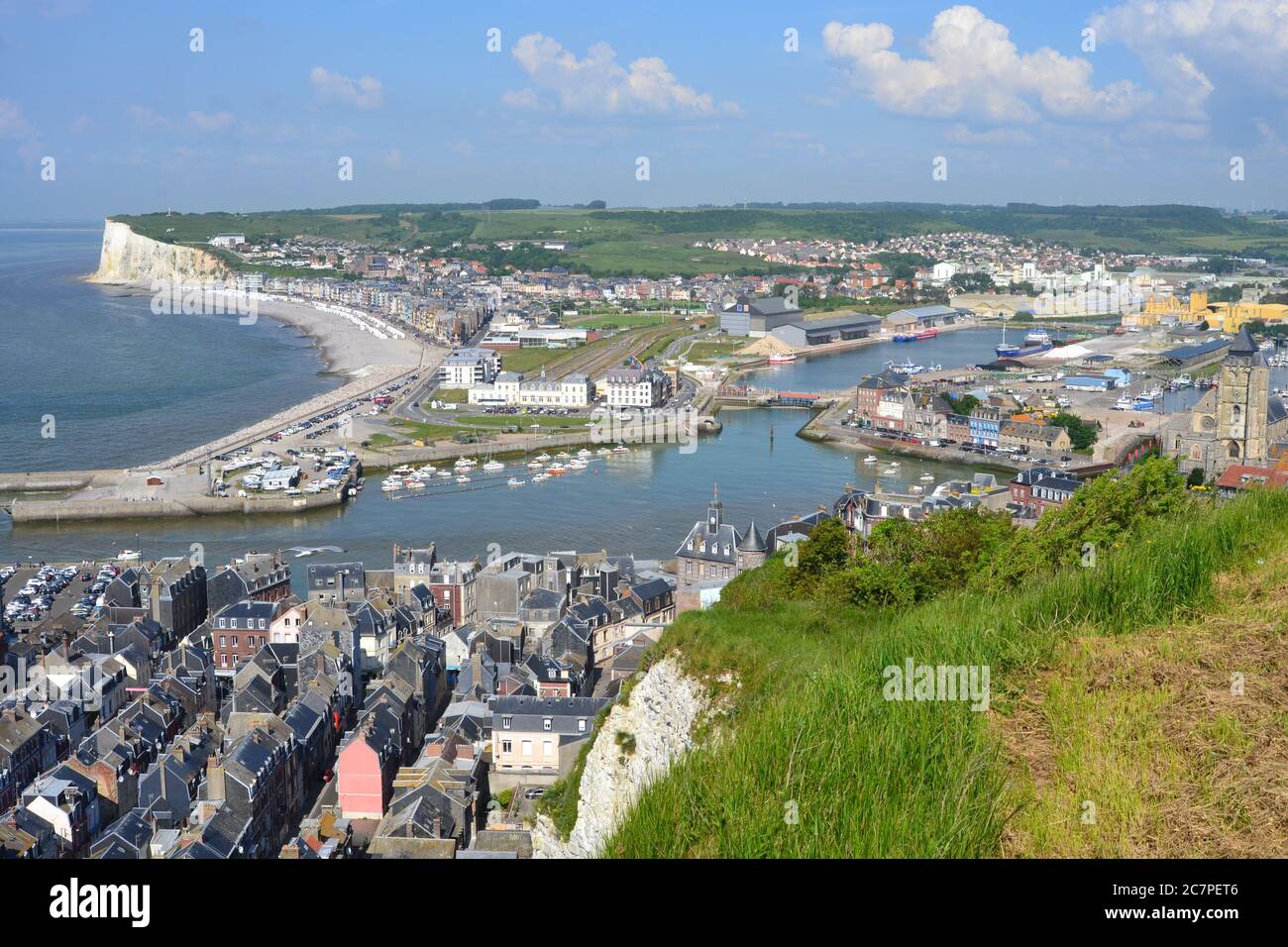 Aerial shot of a city in a bay area with blue ocean and green land in ...