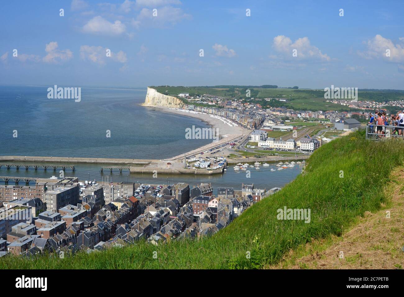 Aerial shot of a city in a bay area with blue ocean and green land in ...