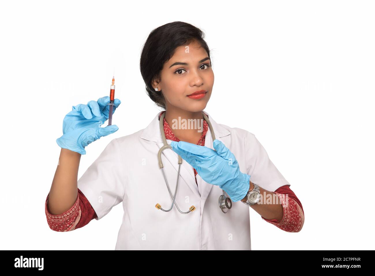 A female doctor with a stethoscope is holding an Injection or Syringe ...