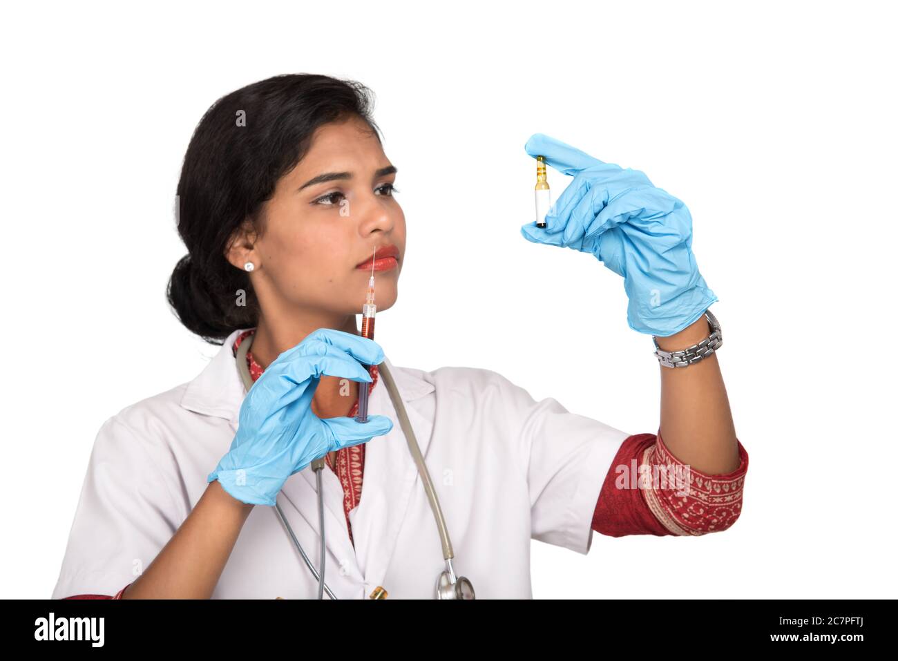 A female doctor with a stethoscope is holding an Injection or Syringe ...