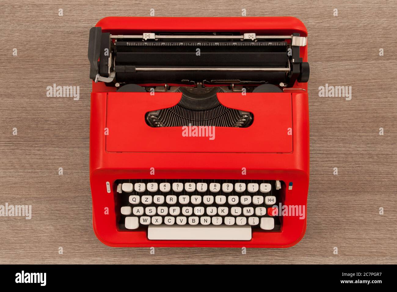 Red mechanical typewriter with white keys on wooden table Stock Photo ...