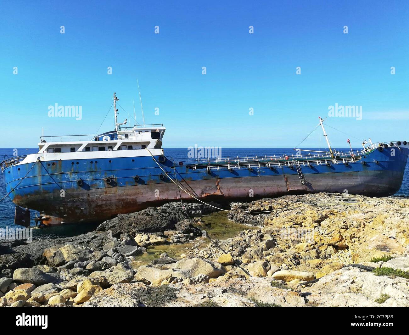 Panoramic shot of a ship completely wrecked and stranded on the rocky ...