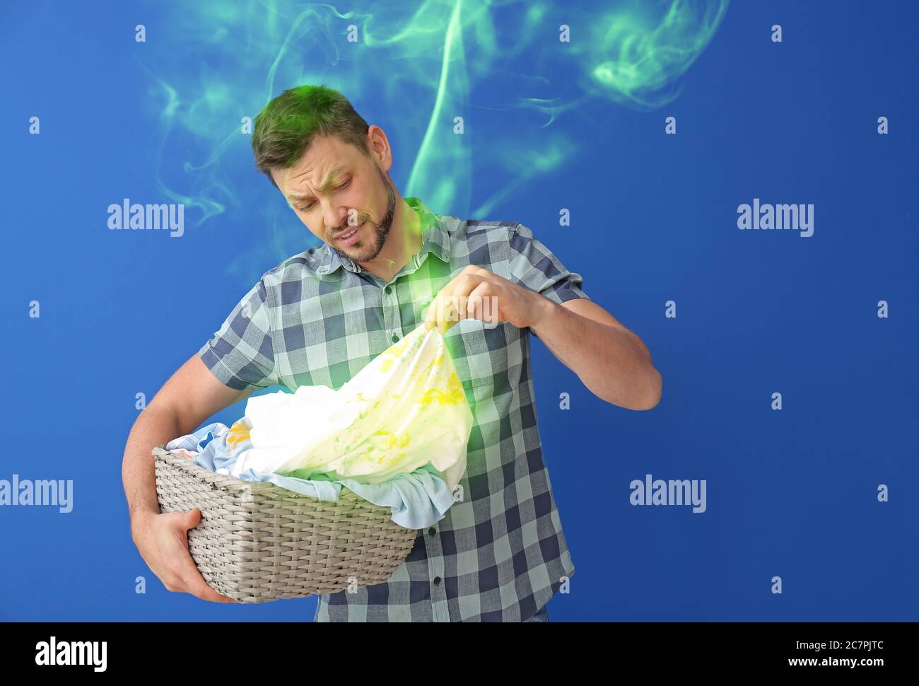 Displeased man with dirty smelly clothes on color background Stock ...
