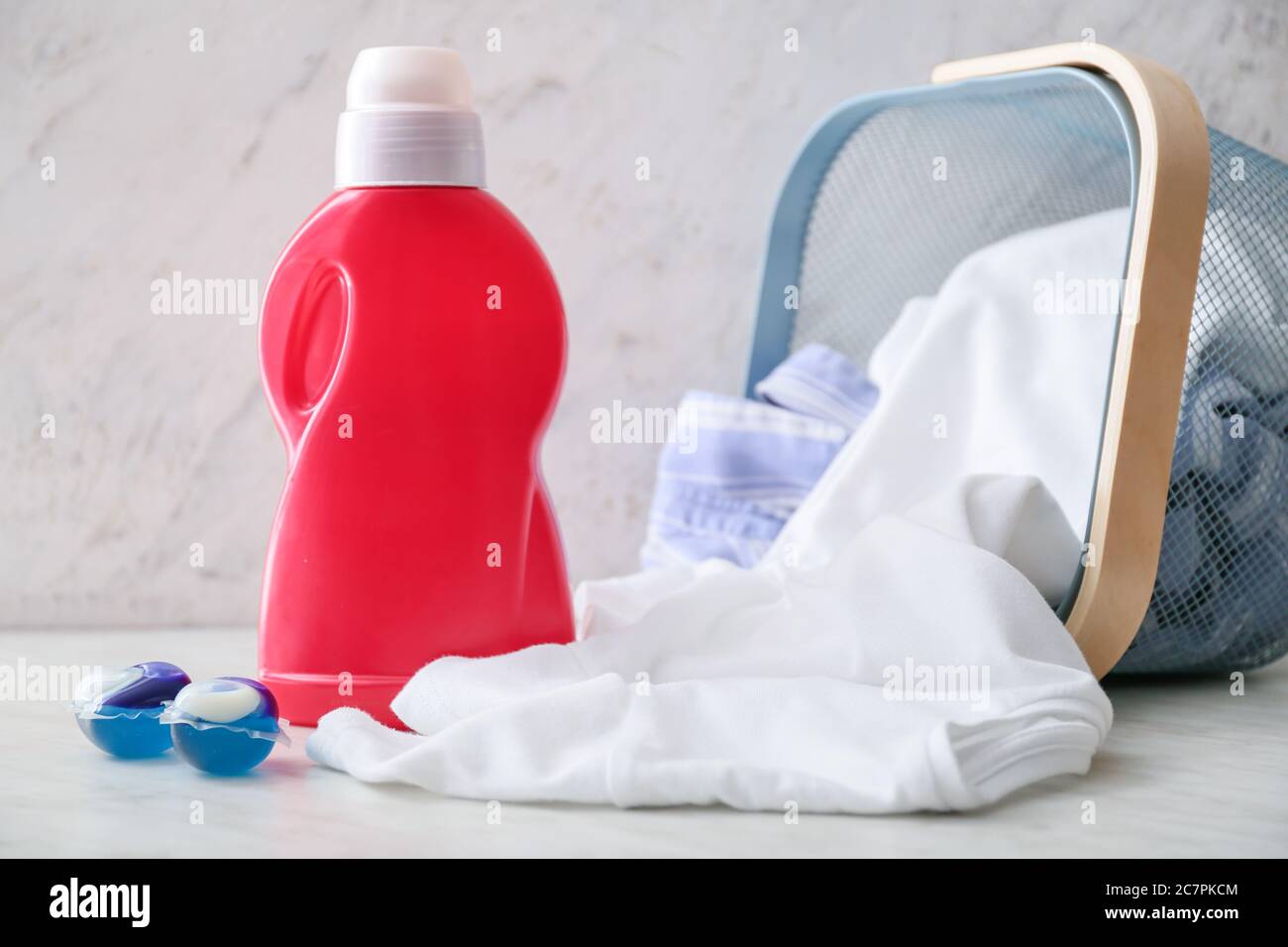 Laundry detergents and basket with clothes on table Stock Photo - Alamy