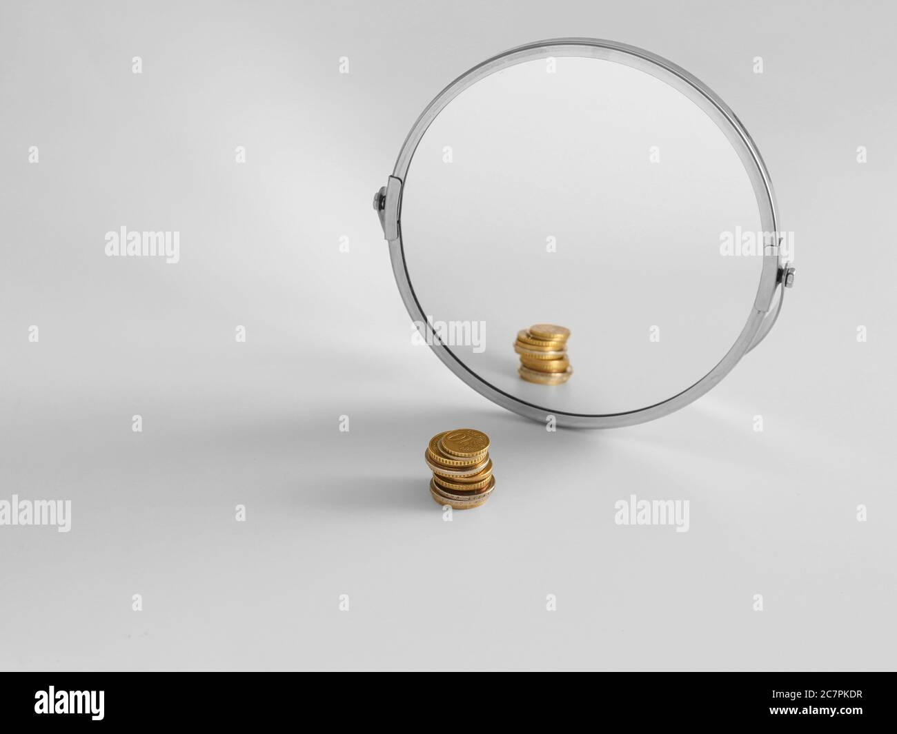 Coins near mirror on light background Stock Photo - Alamy