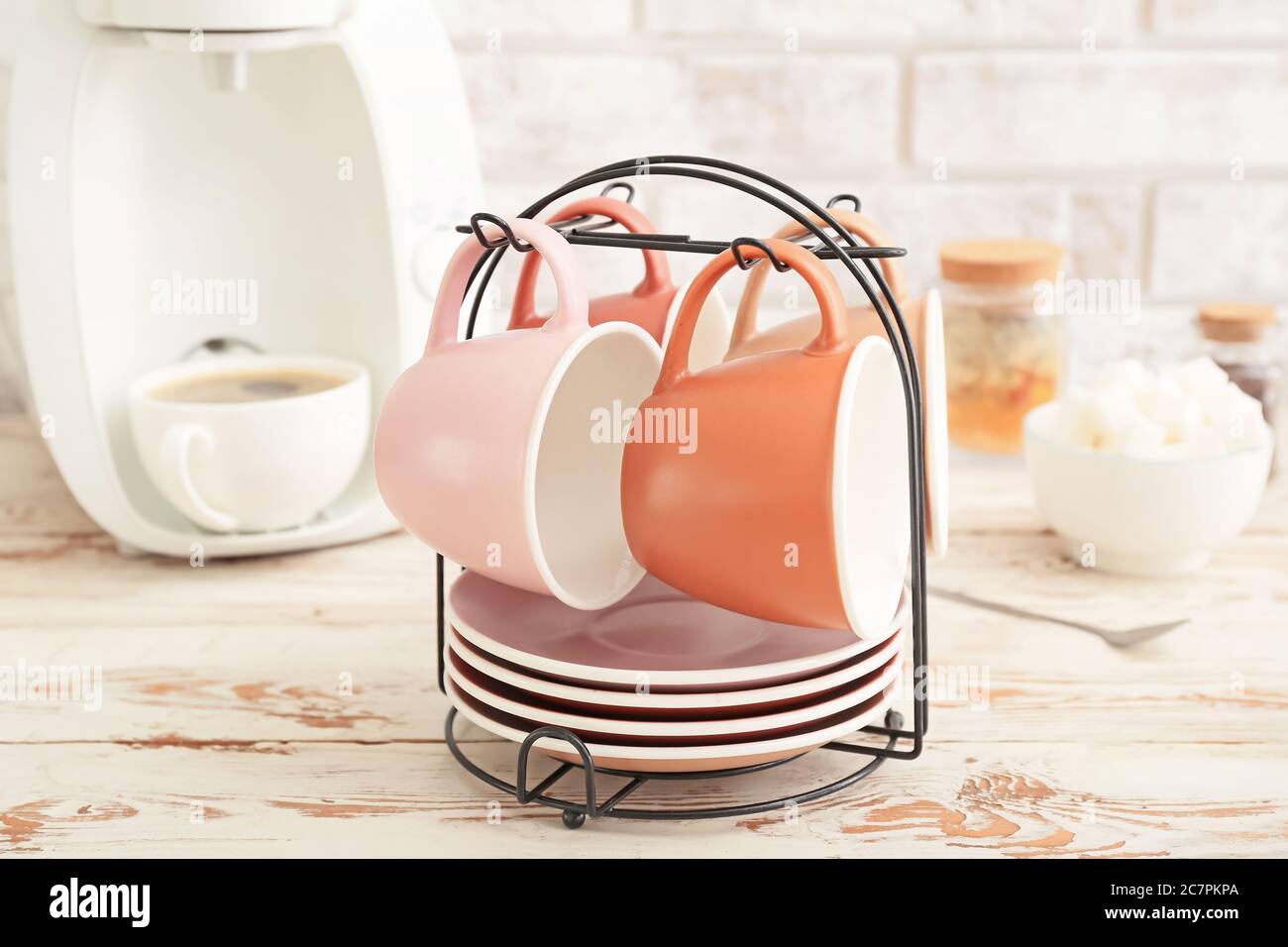 Holder with cups and saucers on kitchen table Stock Photo - Alamy