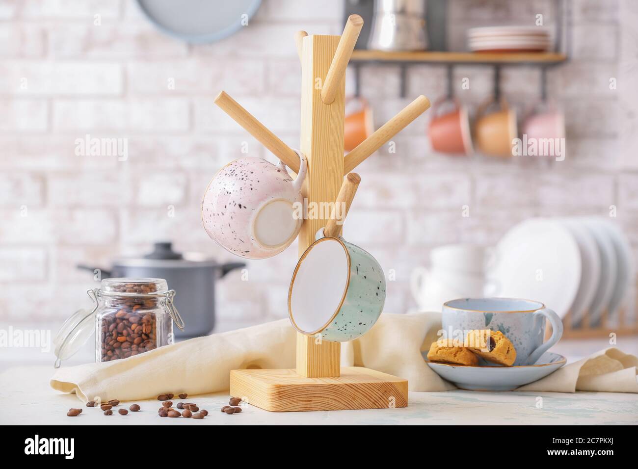 Holder with cups on kitchen table Stock Photo - Alamy