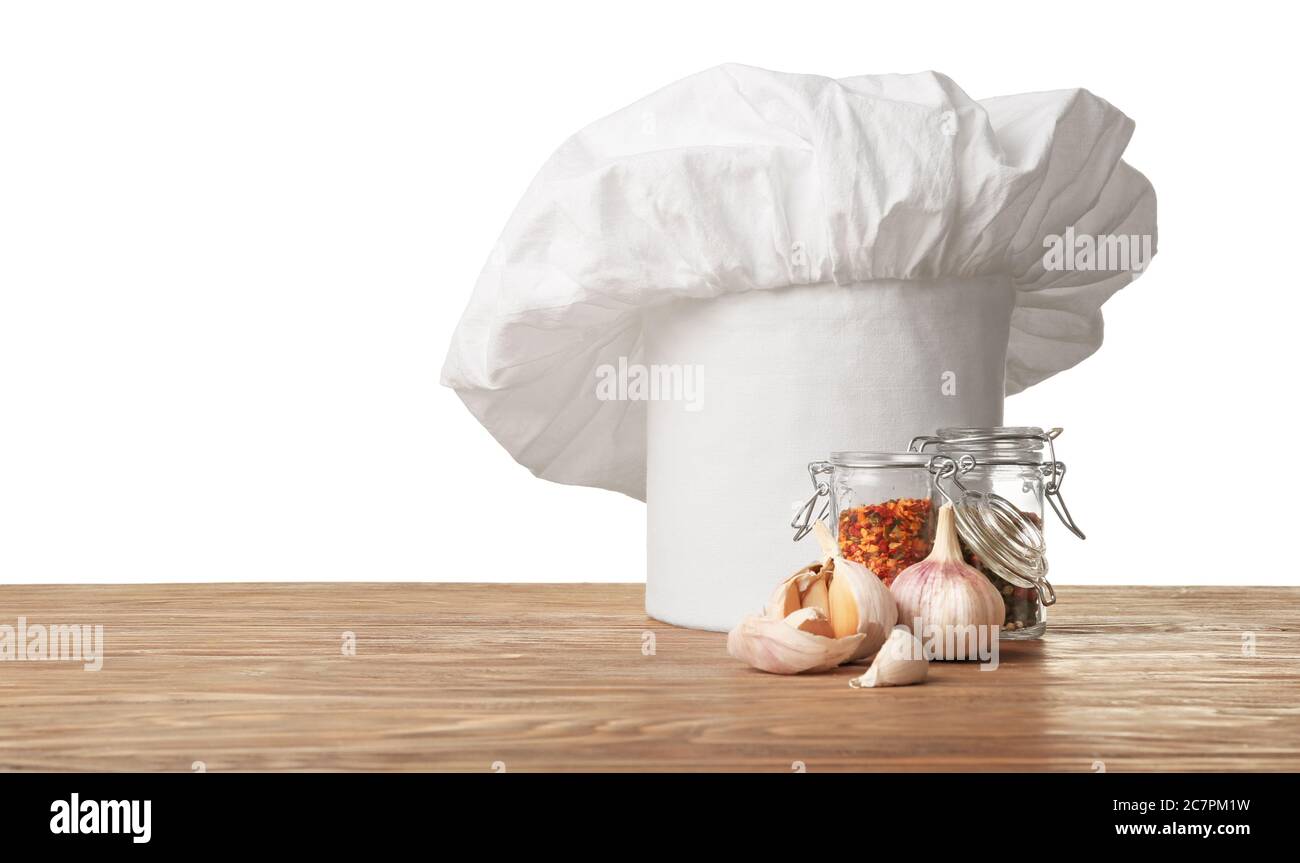 Chef's hat and spices on table against white background Stock Photo - Alamy