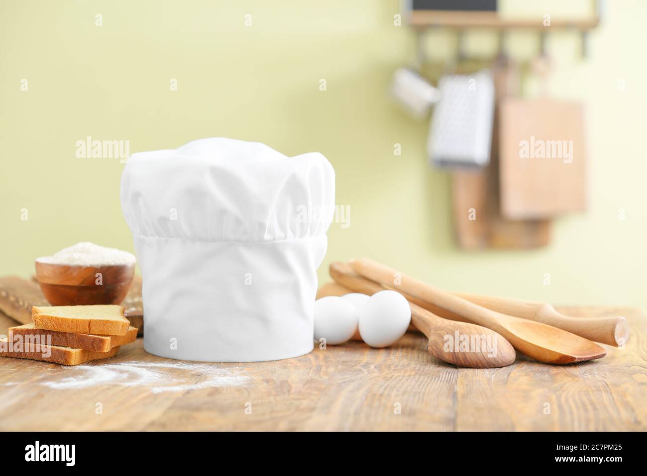Chef's hat, utensils and products on table in kitchen Stock Photo - Alamy