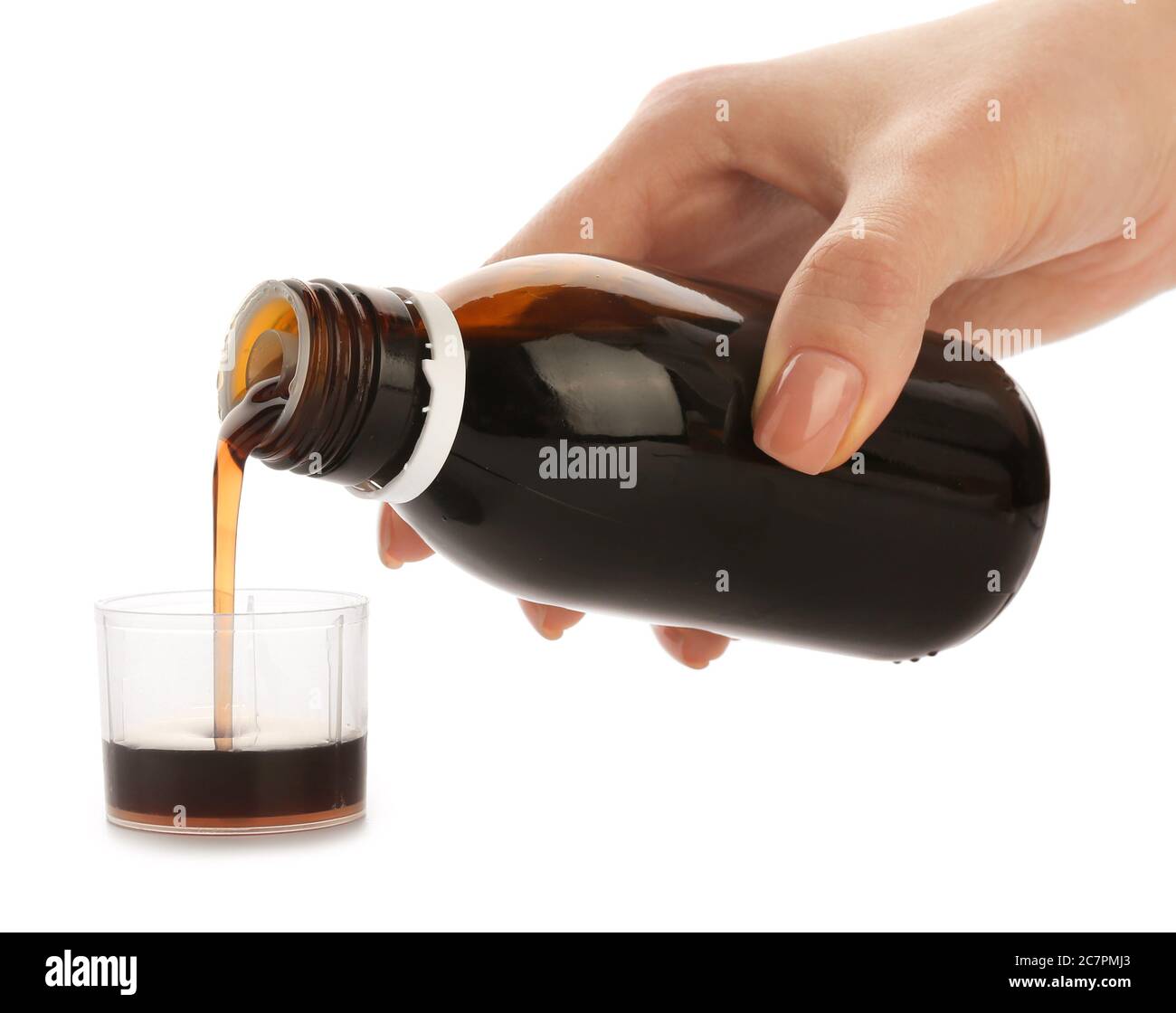 Female hand pouring cough syrup from bottle into cup on white ...