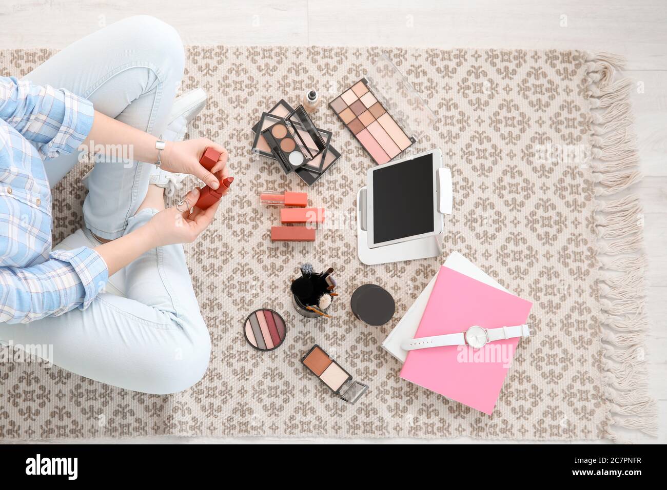 Makeup artist with modern tablet computer and decorative cosmetics ...