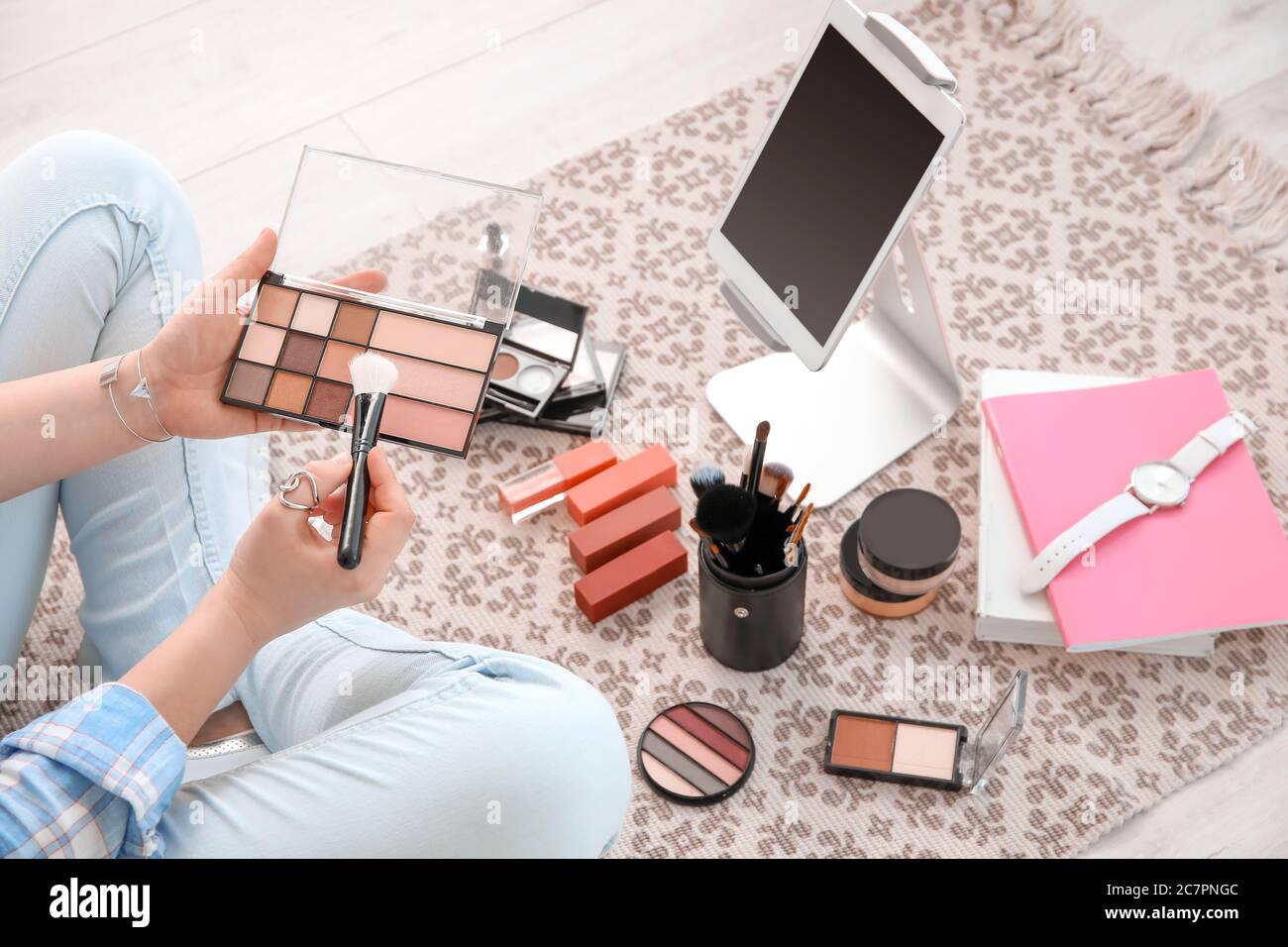 Makeup artist with modern tablet computer and decorative cosmetics ...