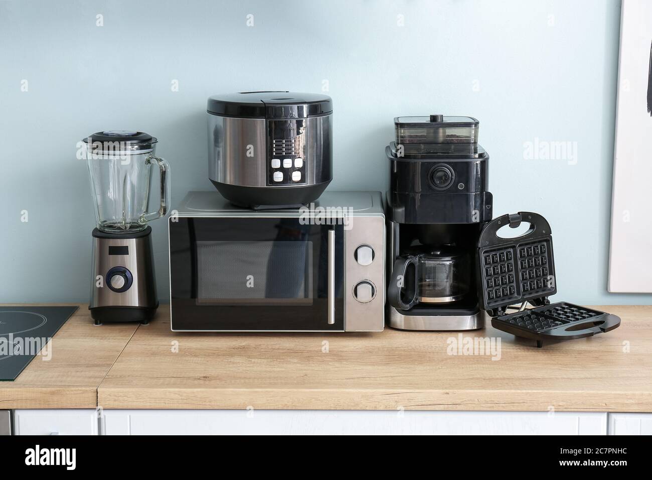 Different household appliances on table in kitchen Stock Photo - Alamy