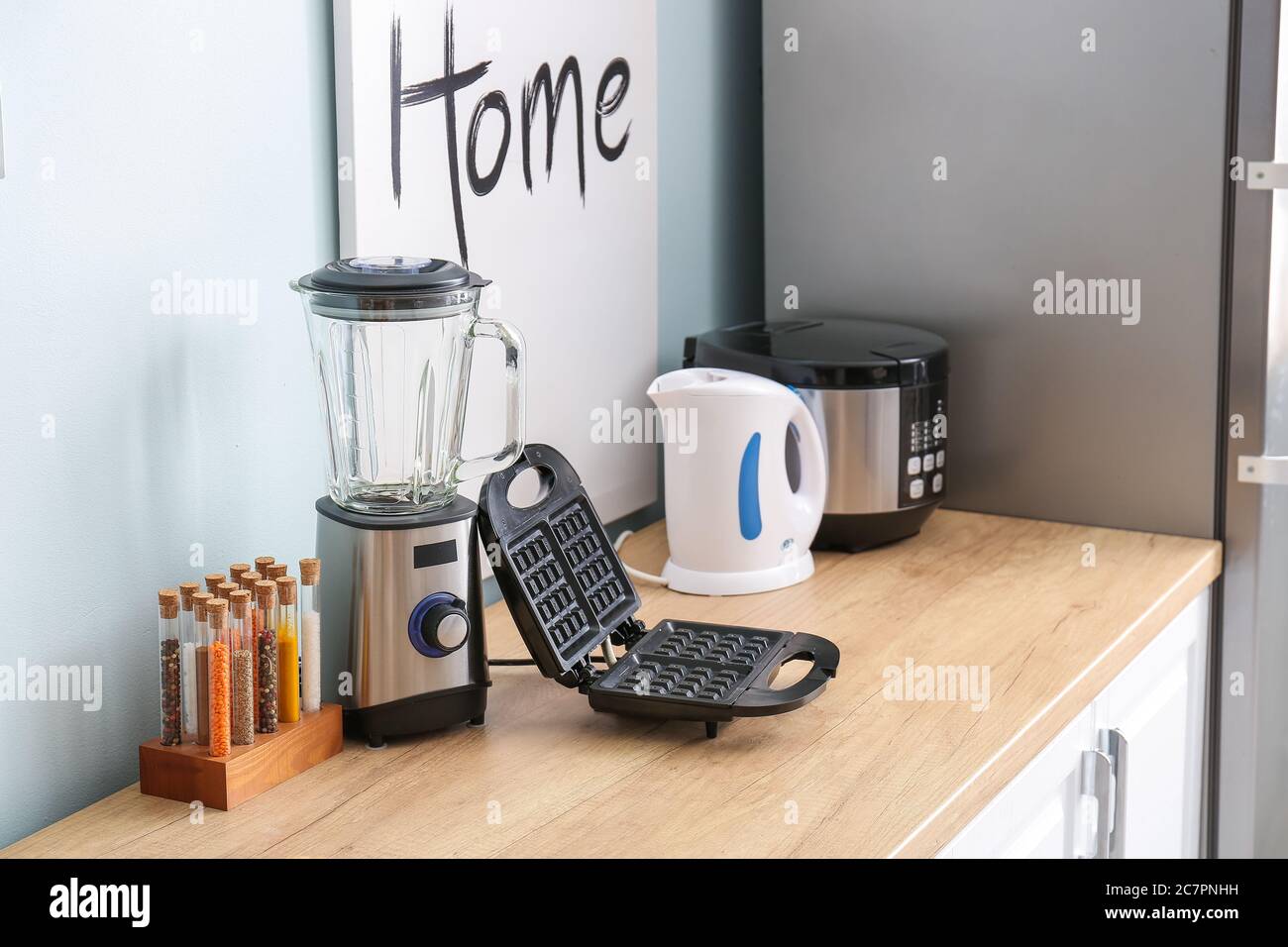Different household appliances on table in kitchen Stock Photo - Alamy
