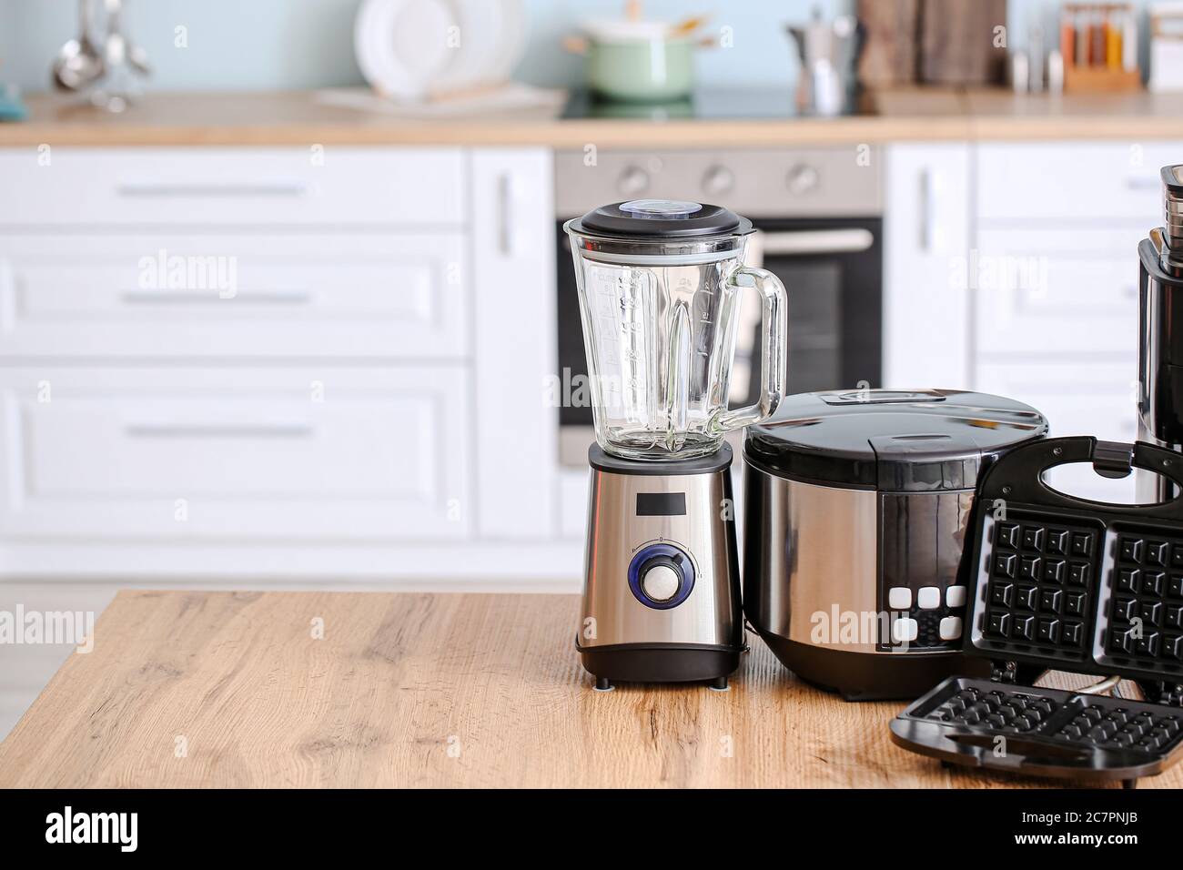 Different household appliances on table in kitchen Stock Photo - Alamy