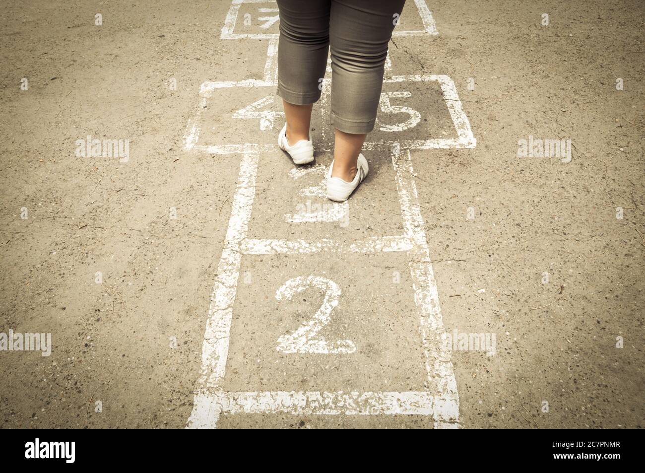 Girl playing hopscotch on the ground Stock Photo - Alamy