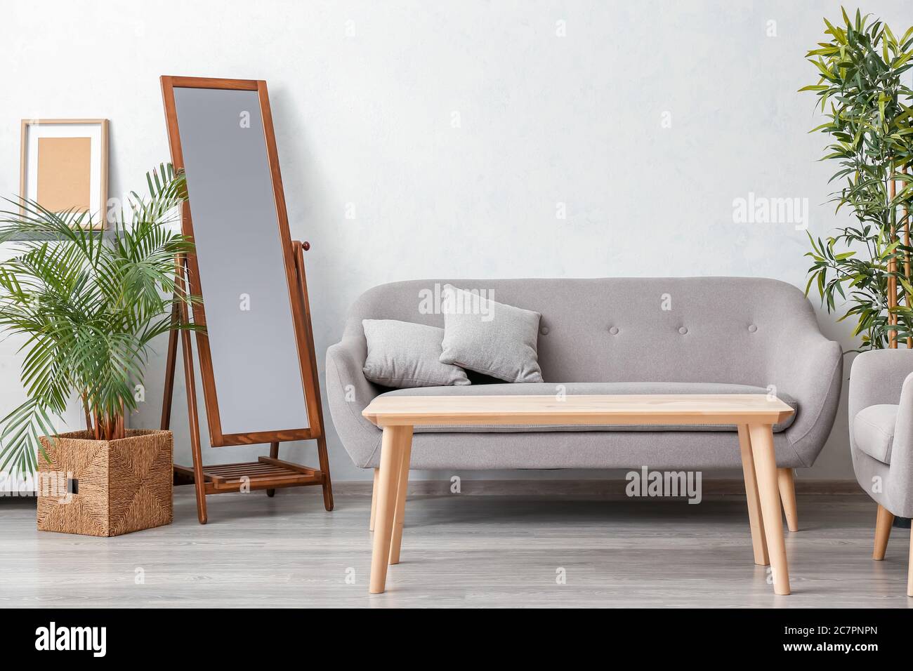 Big mirror, sofa and table in interior of room Stock Photo - Alamy