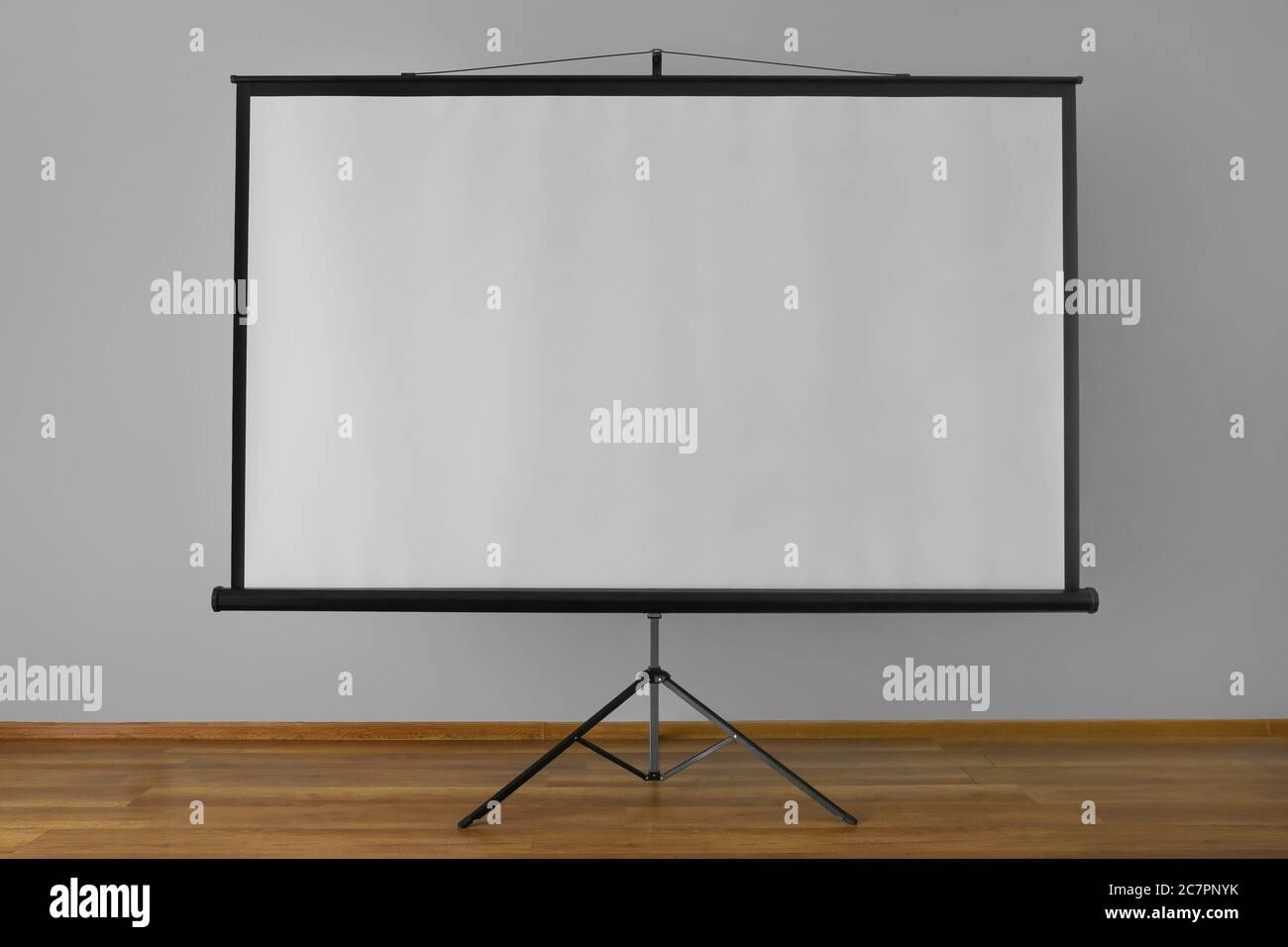Modern projector screen near wall indoors Stock Photo - Alamy