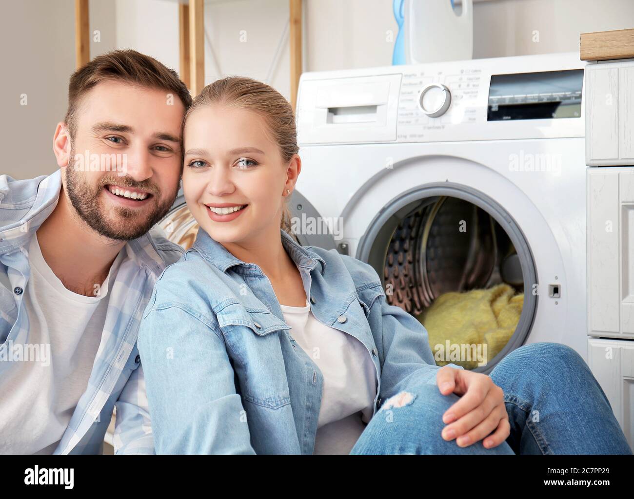 Happy couple doing laundry at home Stock Photo - Alamy