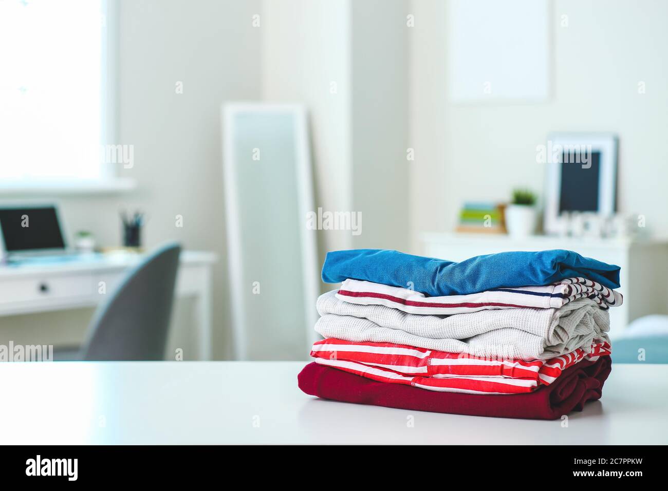 Stack of clean clothes on table in room Stock Photo - Alamy