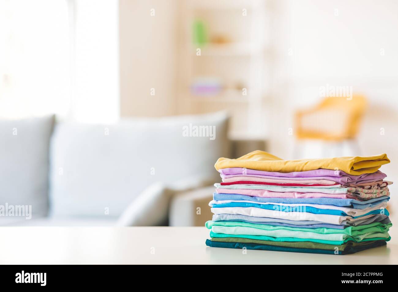 Stack of clean clothes on table in room Stock Photo - Alamy