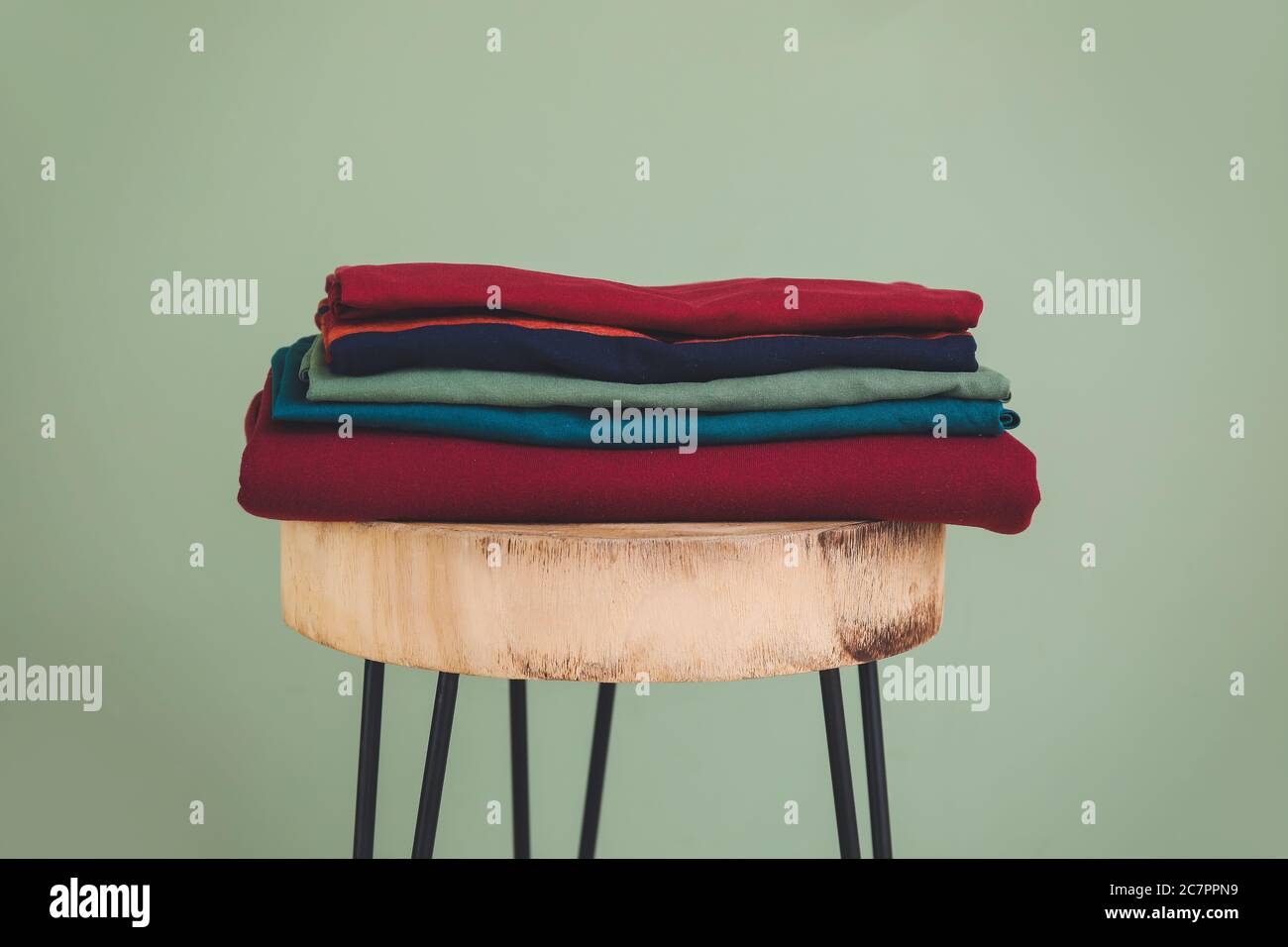Stack of clean clothes on table against color background Stock Photo ...