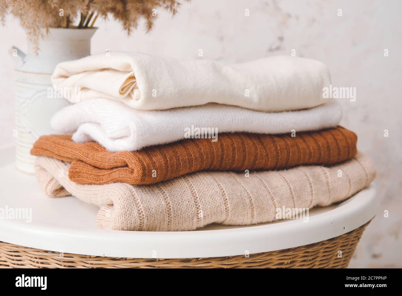 Stack of clean clothes on table in room Stock Photo - Alamy