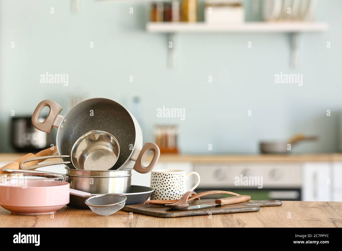 Clean utensils on kitchen table Stock Photo - Alamy