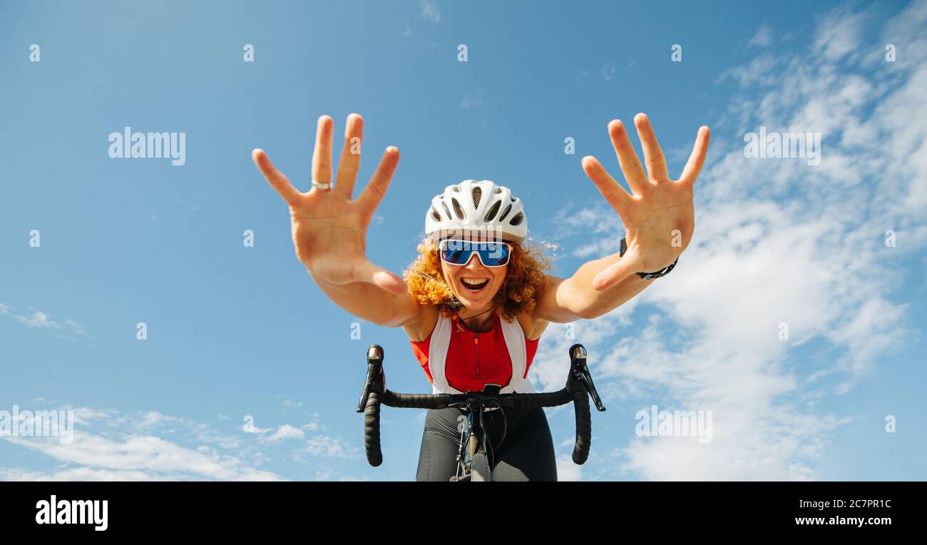 Vigorous young ginger woman riding on a professional bike hands free ...