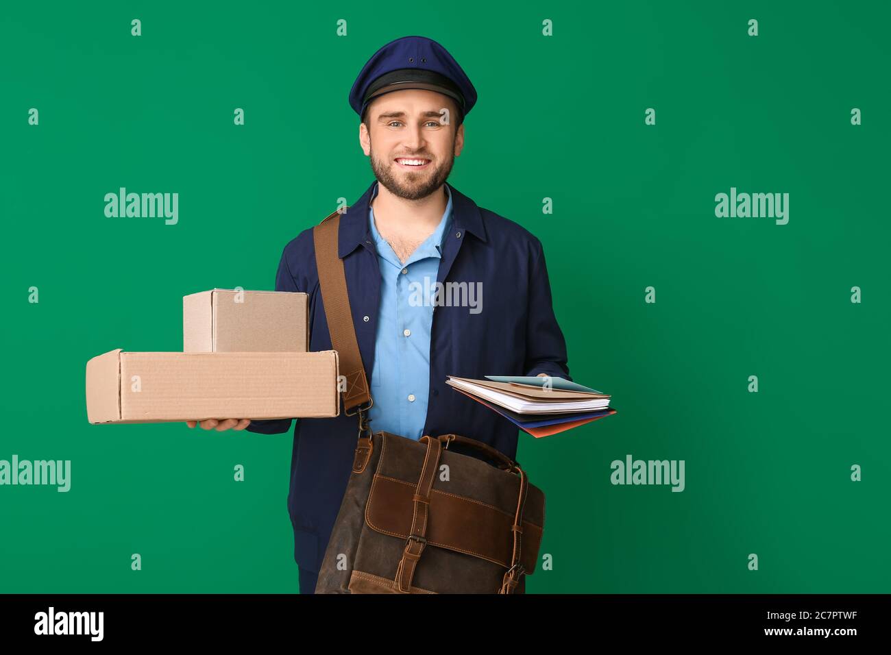 Handsome young postman on color background Stock Photo - Alamy