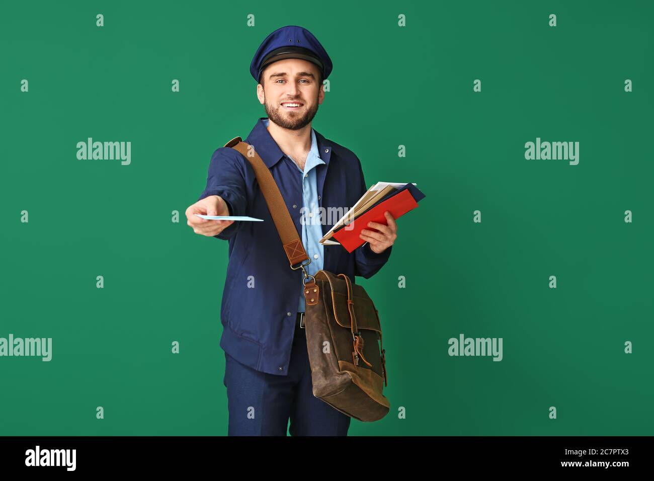 Handsome young postman on color background Stock Photo - Alamy