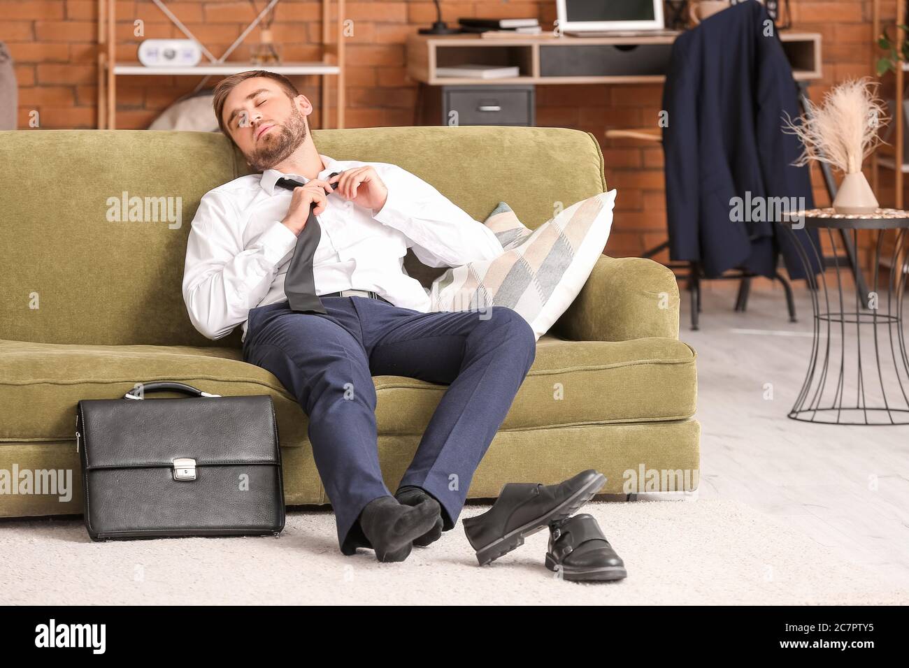 Young businessman resting at home after long working day Stock Photo ...