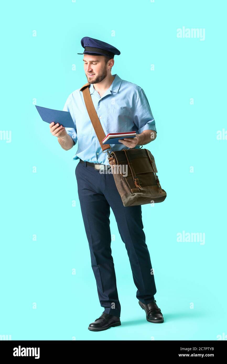 Handsome young postman on color background Stock Photo - Alamy