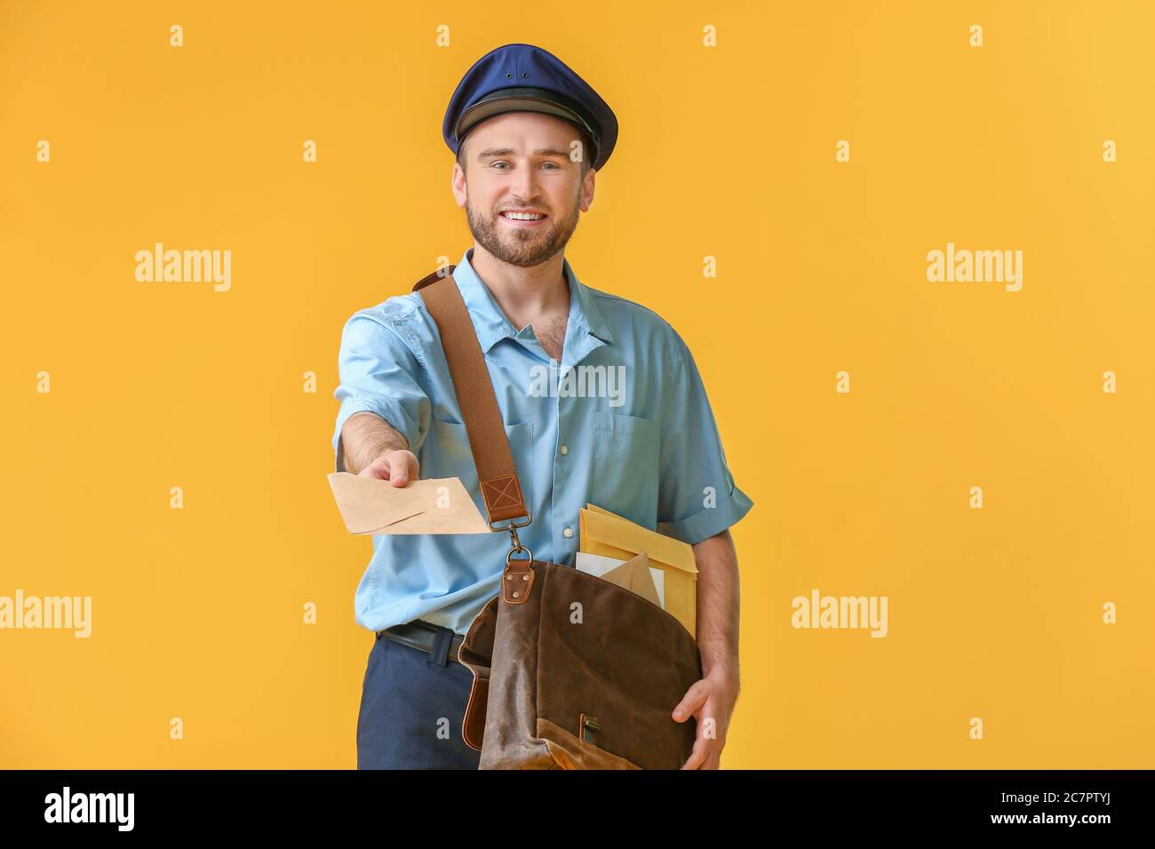 Handsome young postman on color background Stock Photo - Alamy