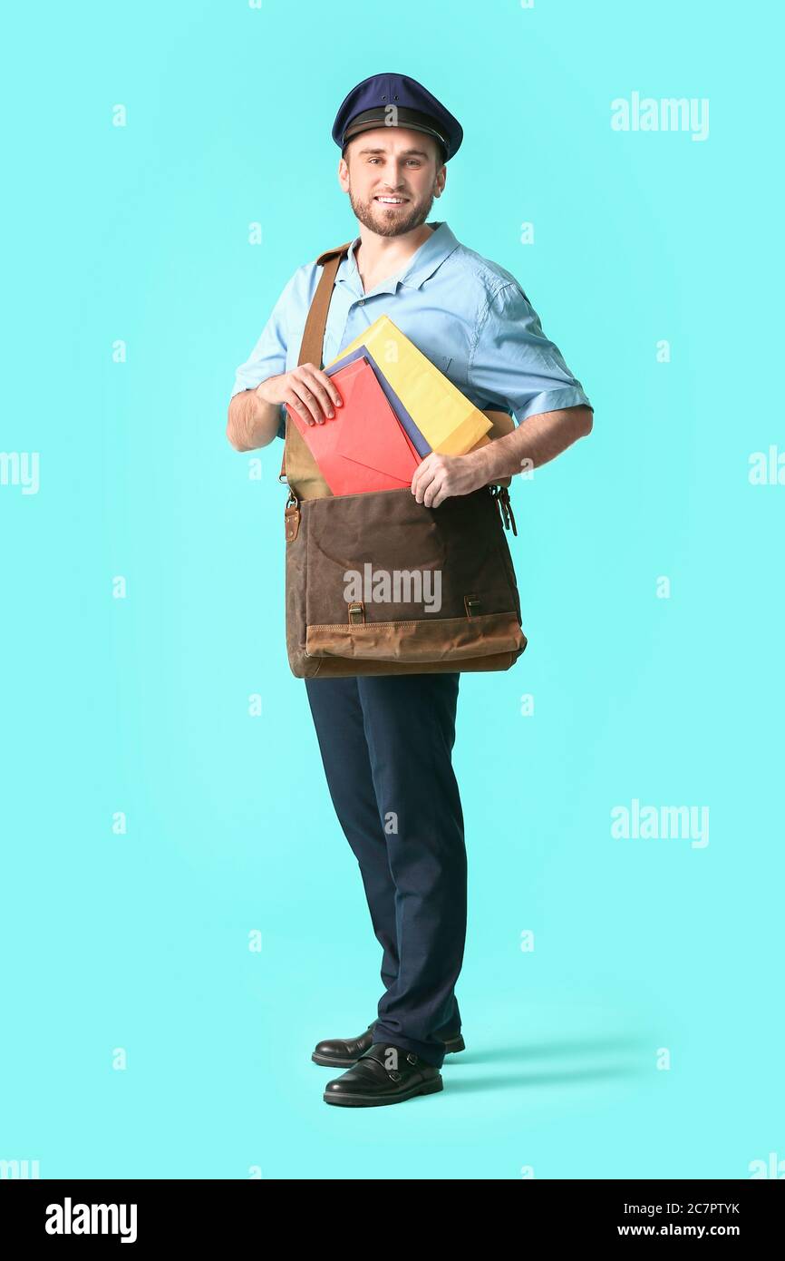 Handsome young postman on color background Stock Photo - Alamy