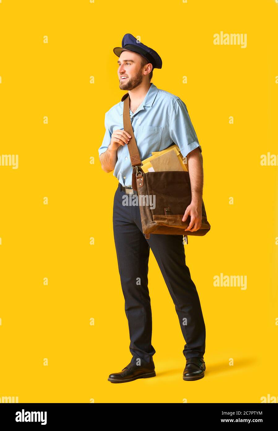 Handsome young postman on color background Stock Photo - Alamy