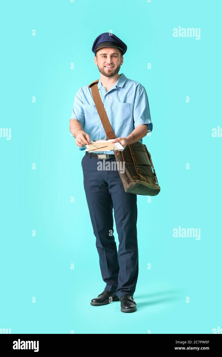 Handsome young postman on color background Stock Photo - Alamy