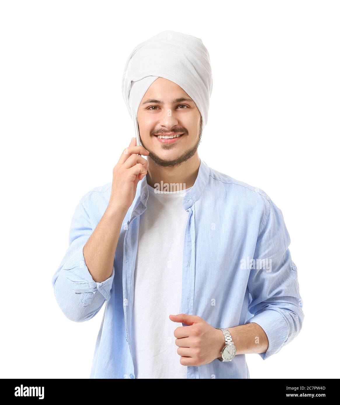 Handsome young Indian man talking by mobile phone on white background ...