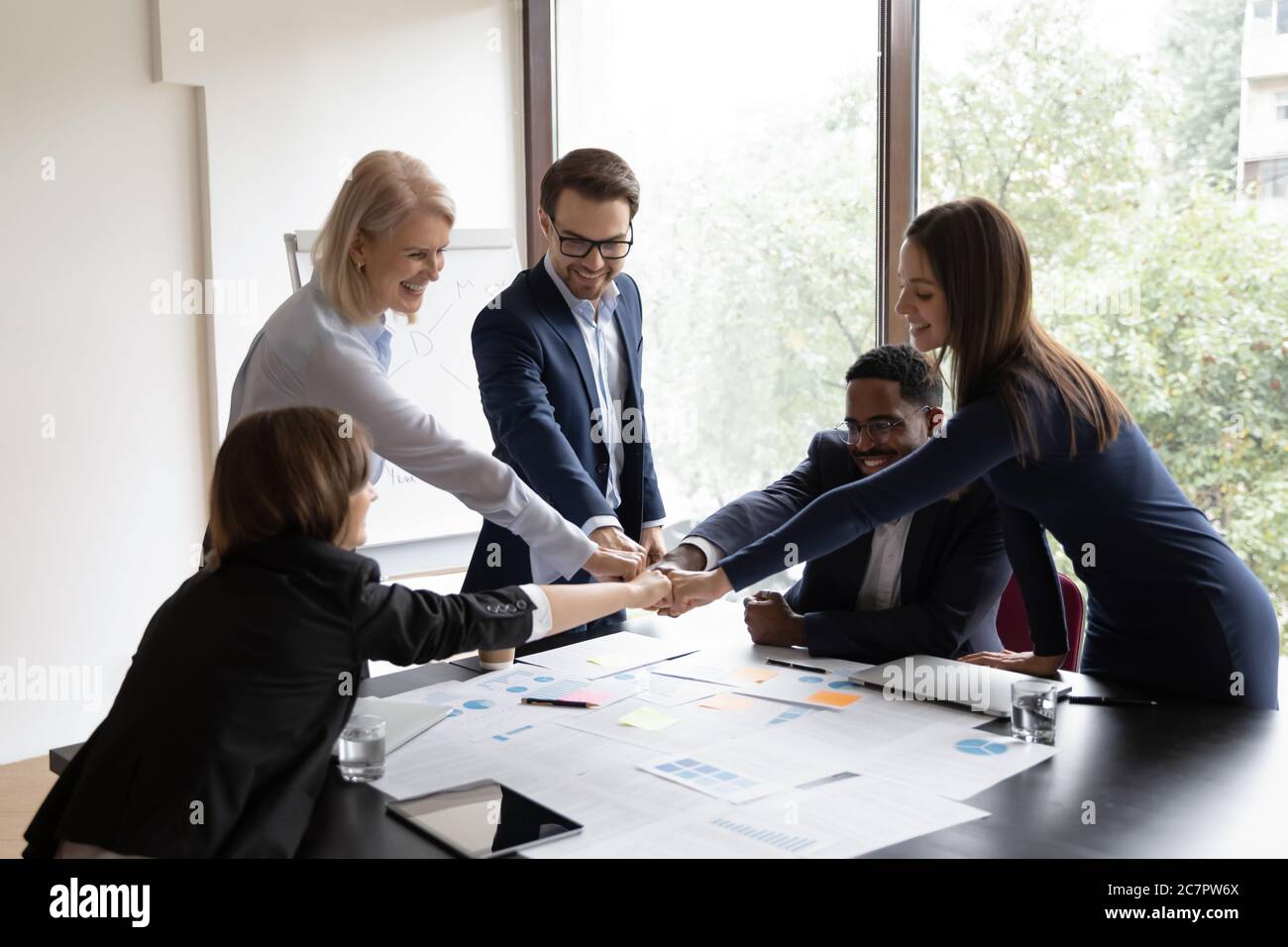 Diverse ethnicity staff puts fists together make circle showing unity ...