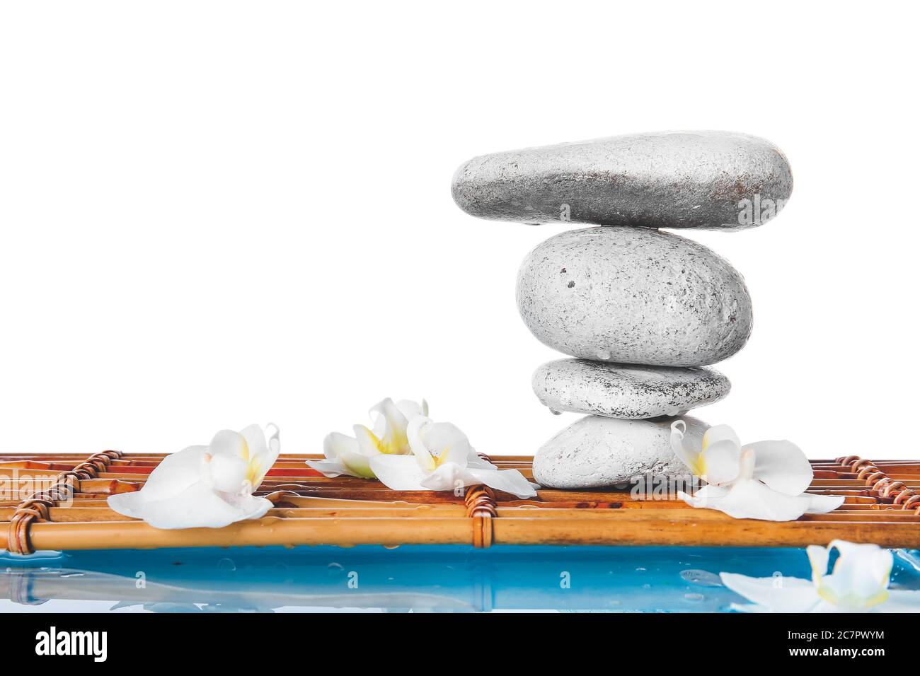 Spa stones, flowers and water against white background Stock Photo - Alamy