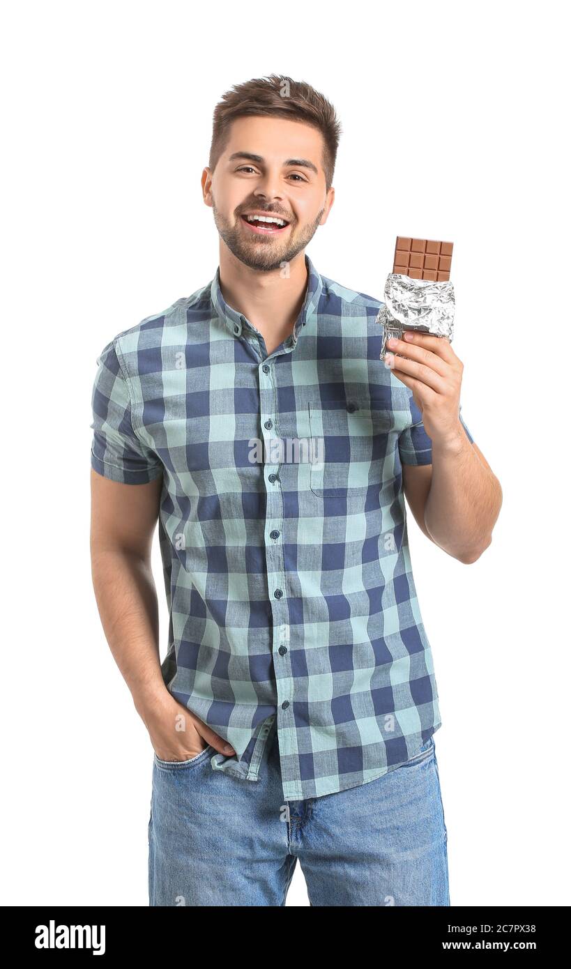 Handsome young man with tasty chocolate on white background Stock Photo ...