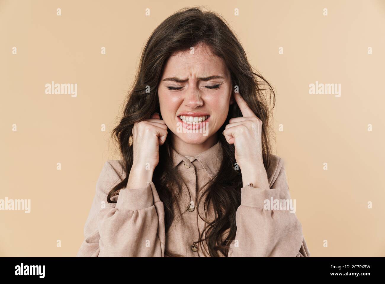 Image of unhappy brunette nice woman plugging her ears isolated over ...