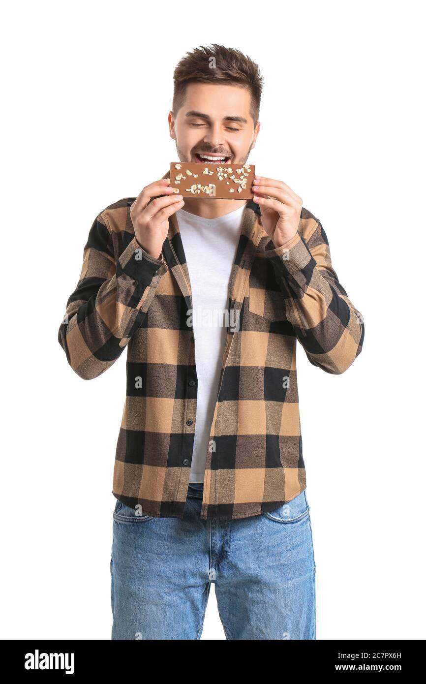 Handsome young man with tasty chocolate on white background Stock Photo ...
