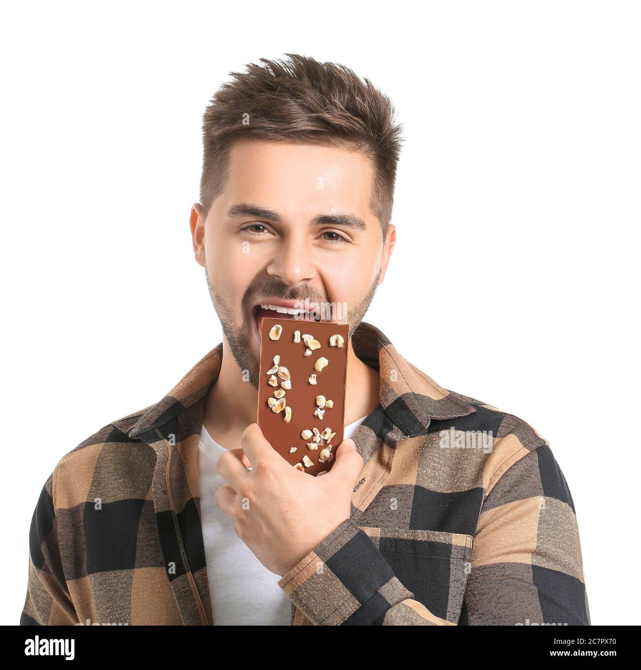 Handsome young man with tasty chocolate on white background Stock Photo ...