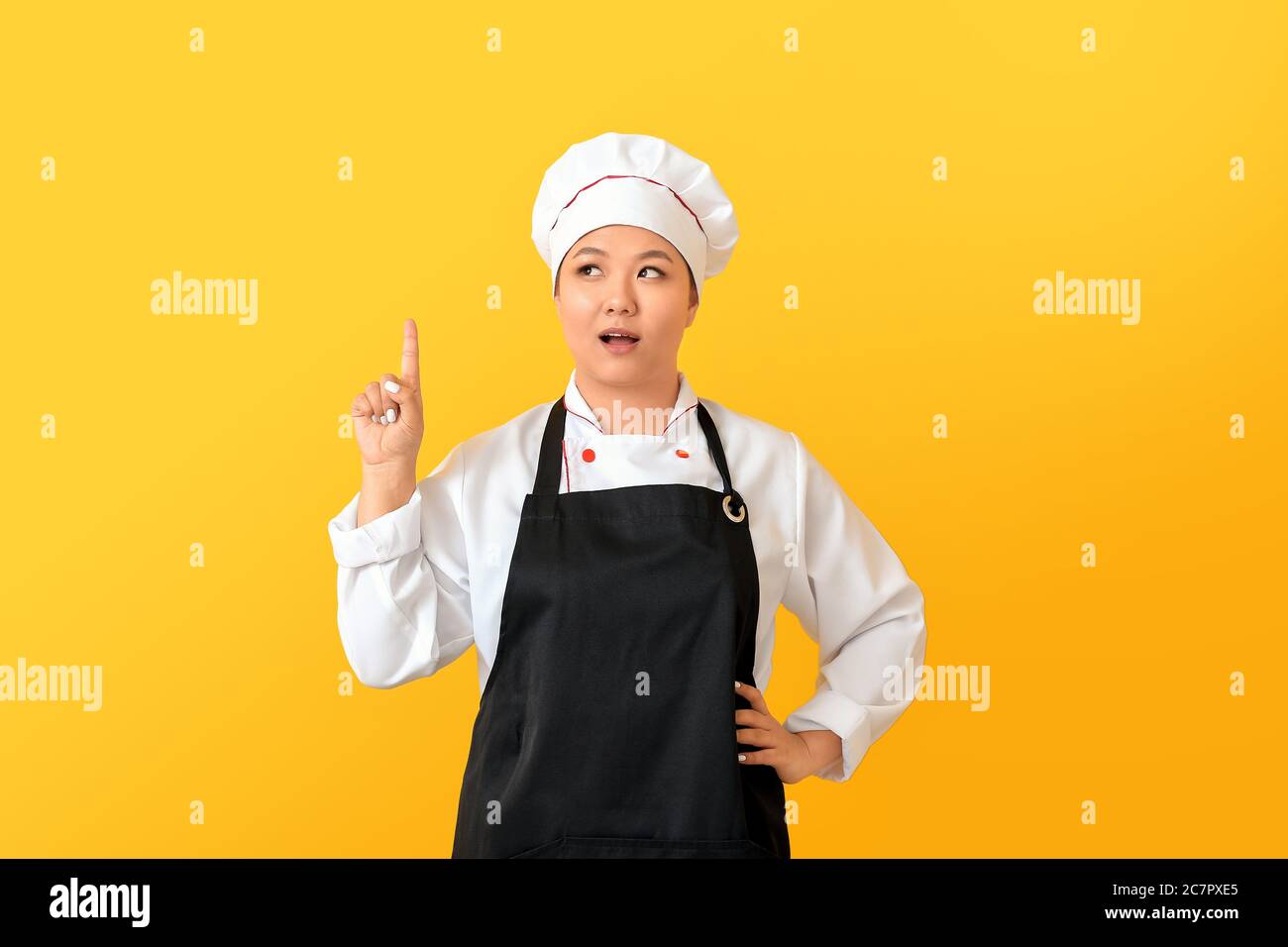 Beautiful Asian chef with raised index finger on color background Stock ...