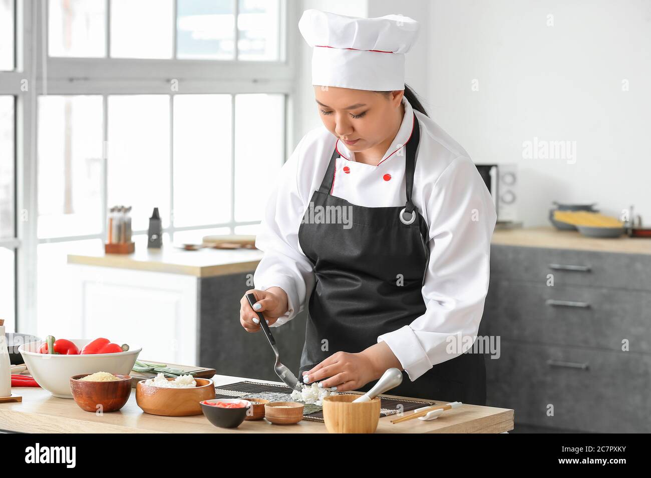 Beautiful Asian chef cooking in kitchen Stock Photo - Alamy