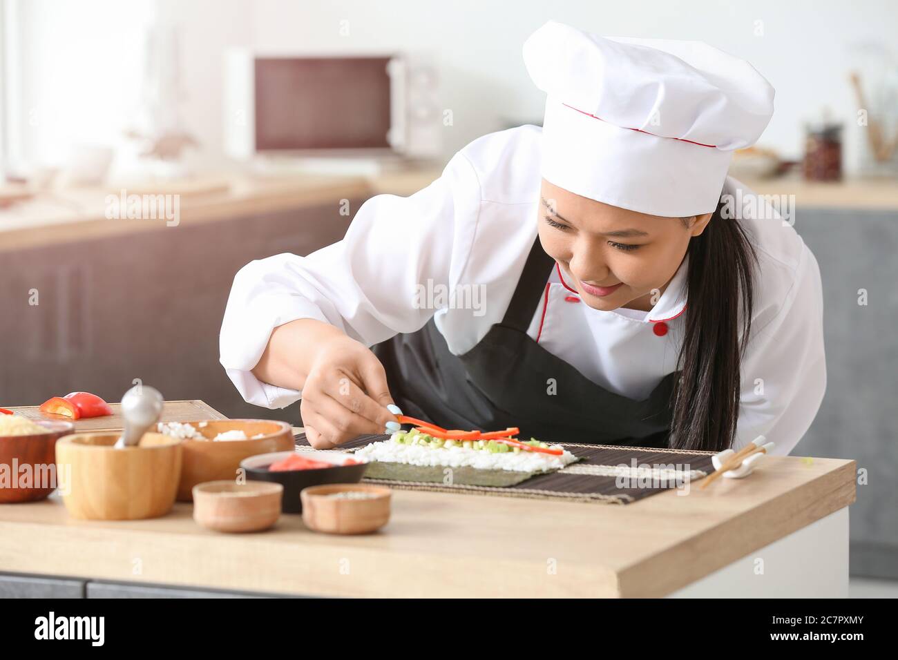 Beautiful Asian chef cooking in kitchen Stock Photo - Alamy