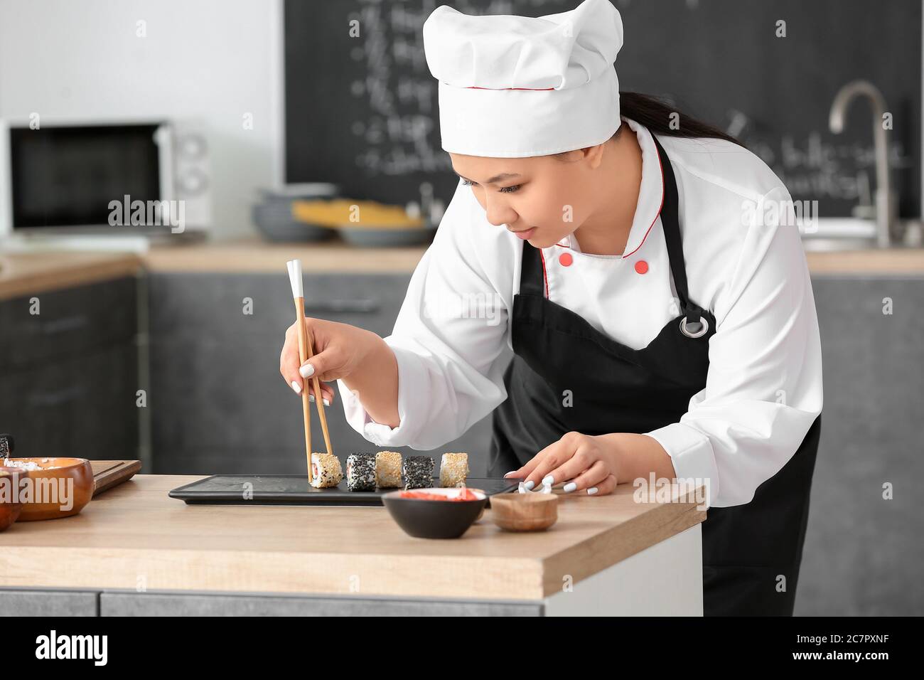 Beautiful Asian chef cooking in kitchen Stock Photo - Alamy